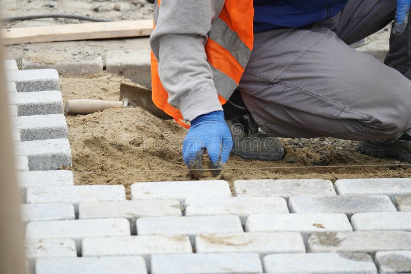 Worker Laying Pavers on a Construction Site in Daylight Stock Image ...
