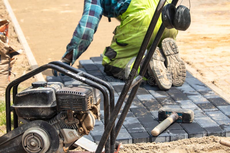 A Worker Laying Paving Stones at a Sidewalk Construction Site, Close Up ...