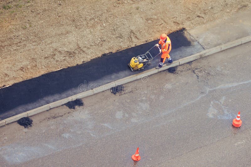 Asphalt a New on the Road and a Tractor on Laying of Asphalt Stock ...