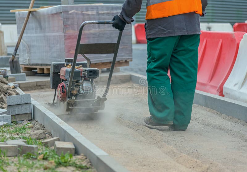 Worker Lays Asphalt. Site Construction Preparation. Sand Tamper Stock ...