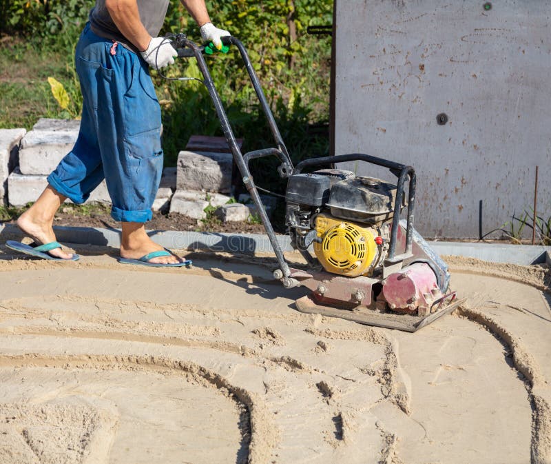 A Worker Lays Down Gravel and Sand for Paving Slabs. Stock Photo ...