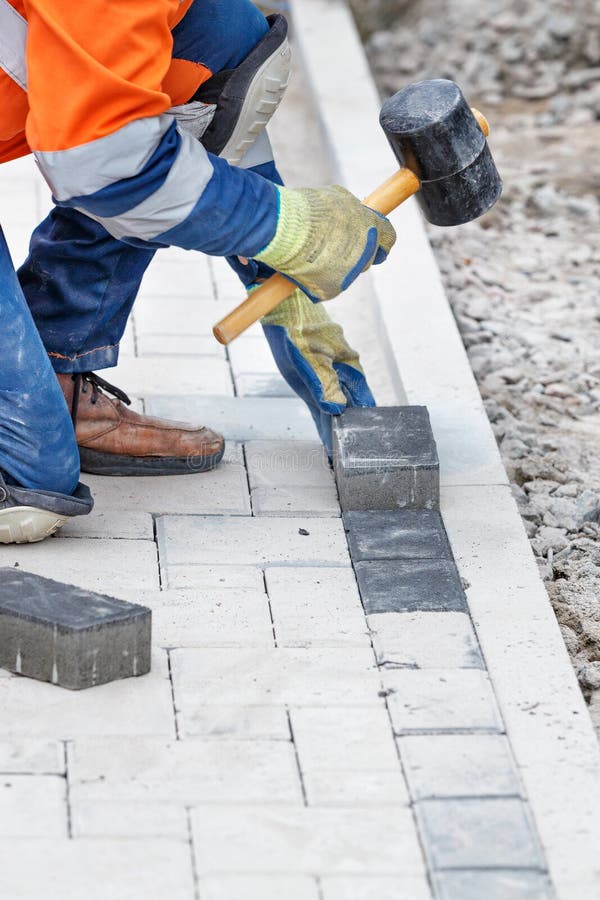 A Worker Lays Down Paving Slabs with a Rubber Hammer on a Pedestrian ...