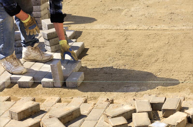The Worker Lays the Pavement Slabs on the Prepared Flat Sandy Ground on ...