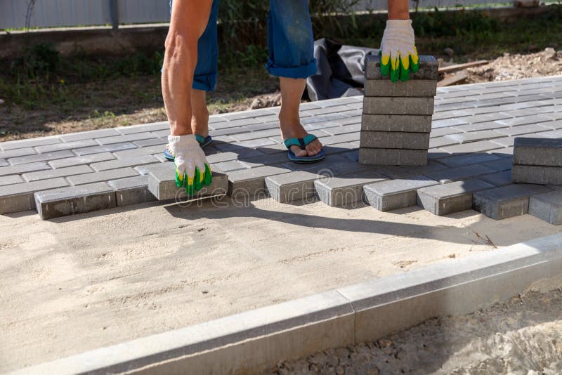 A worker lays paving slabs stock image. Image of street - 231994079