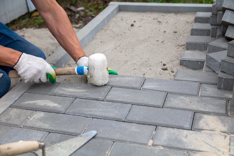 A worker lays paving slabs stock image. Image of sidewalk - 233621291