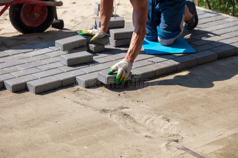 A worker lays paving slabs stock photo. Image of concrete - 234803966