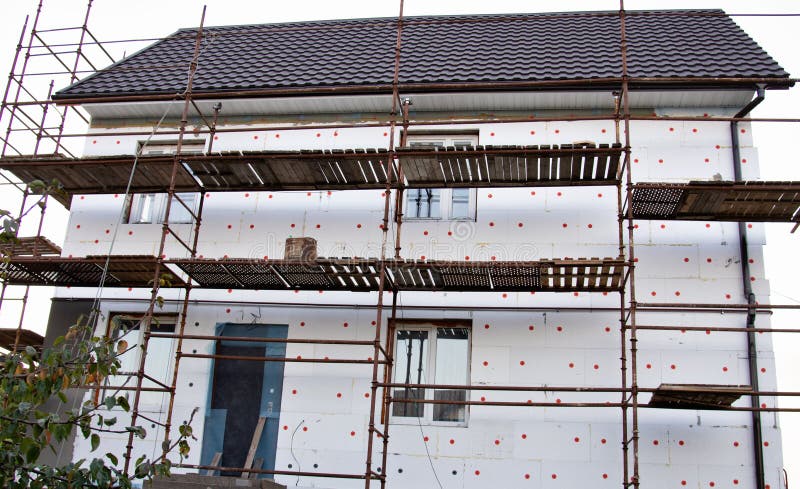 A Worker Lays Wall Tiles on the Wall of a House Using Scaffolding Stock ...