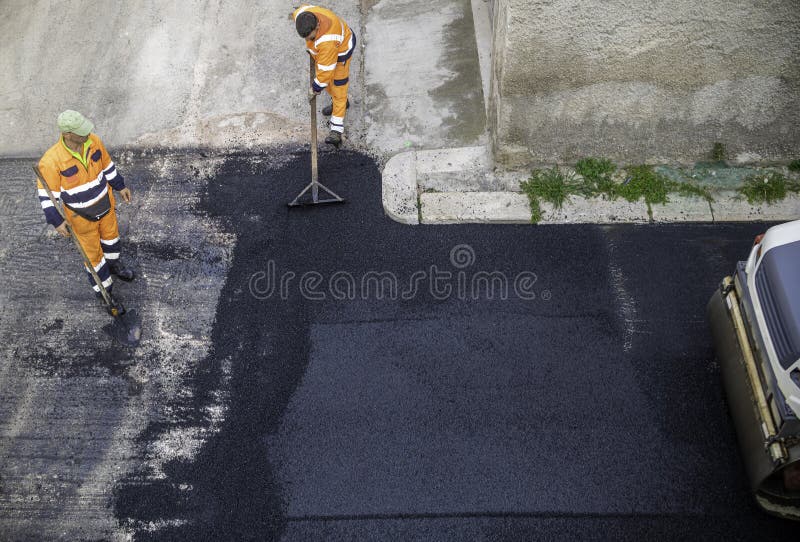 Worker Leveling Fresh Asphalt during Asphalt Pavement Repair or ...