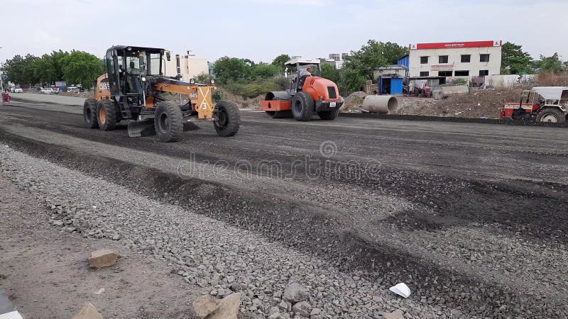 Road Construction and Repairing Works. Worker Leveling Fresh Asphalt on ...