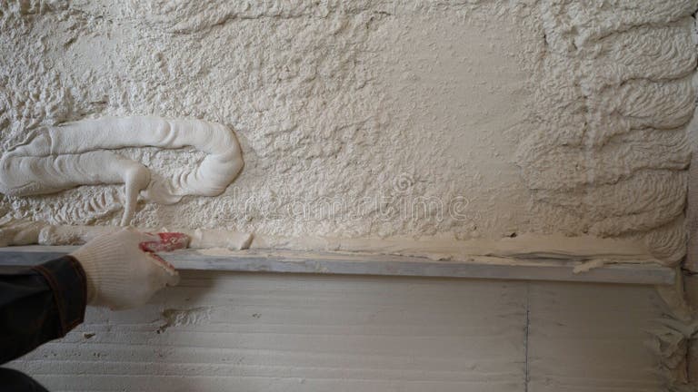 The Process of Leveling Plaster on a Wall Using a Tool. the Worker ...