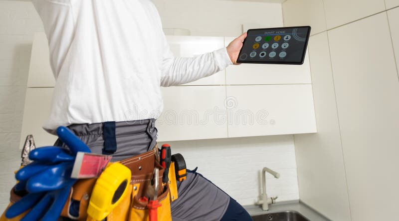 A Worker Looks at a Tablet Computer. Master with an Electronic Tablet ...