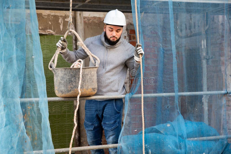 Worker Lowering Down Bucket with Construction Mortar Stock Image ...