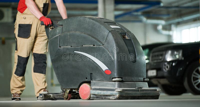 Worker with Machine Cleaning Floor in Parking Garage. Stock Image ...