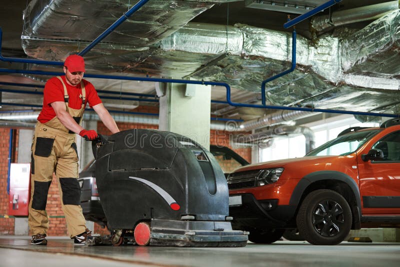 Worker with Machine Cleaning Floor in Parking Garage. Stock Image ...