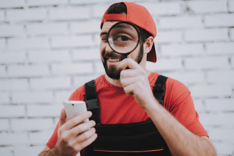 Worker with Magnifying Glass and Mobile Phone. Stock Photo - Image of ...