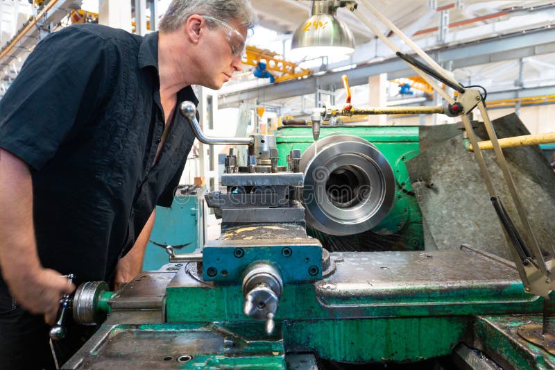 A Worker, a Man in a Black Shirt and Goggles, Controls a Mechanical ...