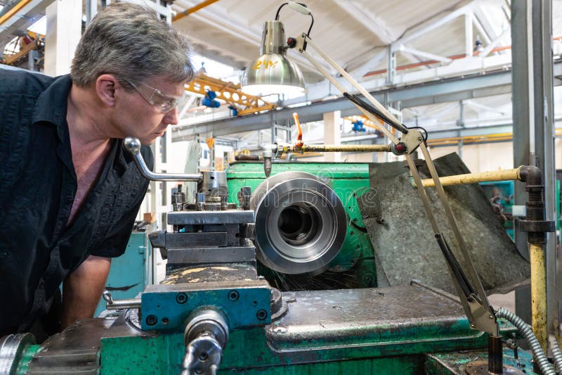 A Worker, a Man in a Black Shirt and Goggles, Controls a Mechanical ...