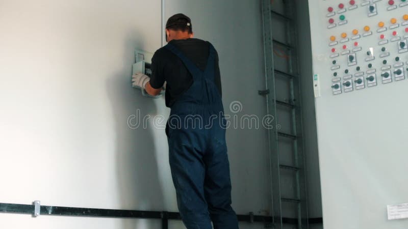 At the Power Substation. Worker Checking Connections on the Electric ...