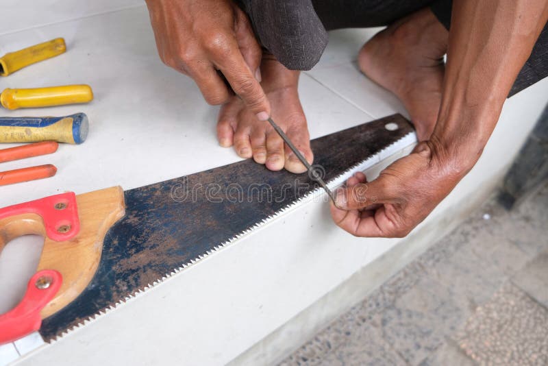 A Worker Man Pose Doing Sharpening of His Old Rusty Saw Tooth in Manual ...