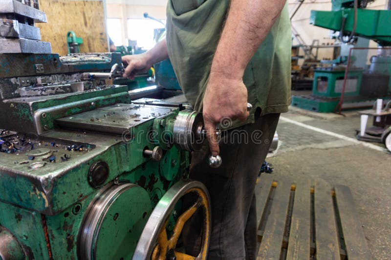 Worker, a Man Processes Metal Products on a Machine. Turning Work in ...