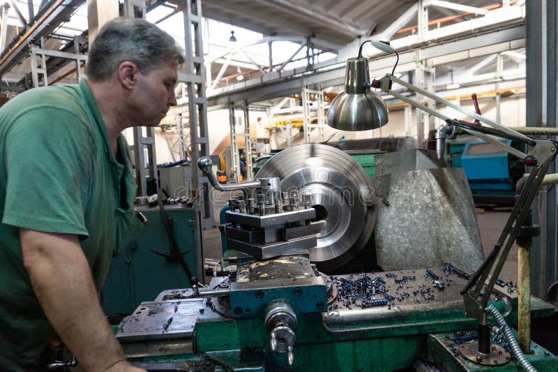 Worker, a Man Processes Metal Products on a Machine. Turning Work in ...