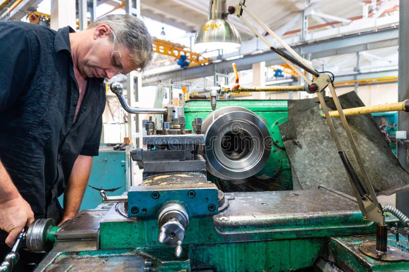 Worker, a Man Processes Metal Products on a Machine. Turning Work in ...