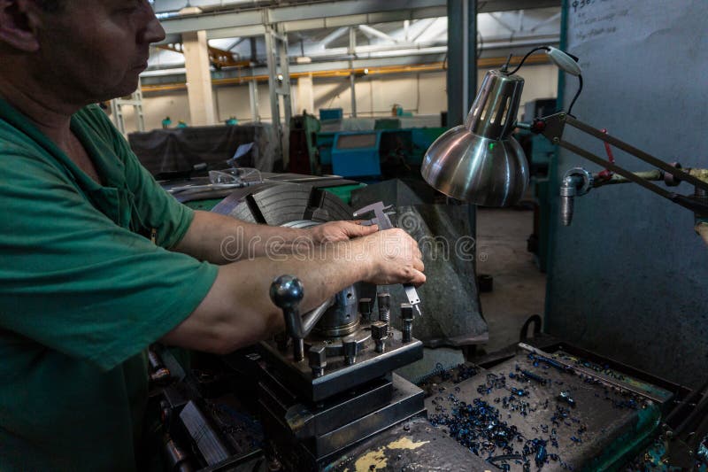Worker, a Man Processes Metal Products on a Machine. Turning Work in ...