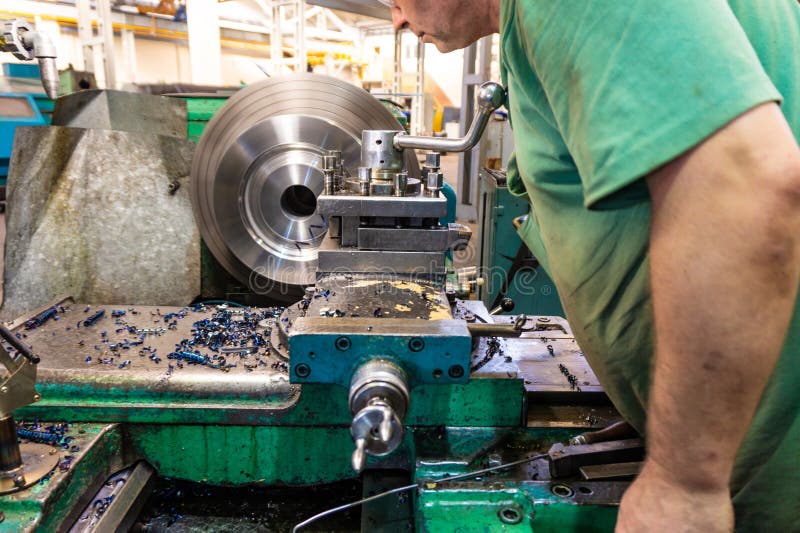 Worker, a Man Processes Metal Products on a Machine. Turning Work in ...