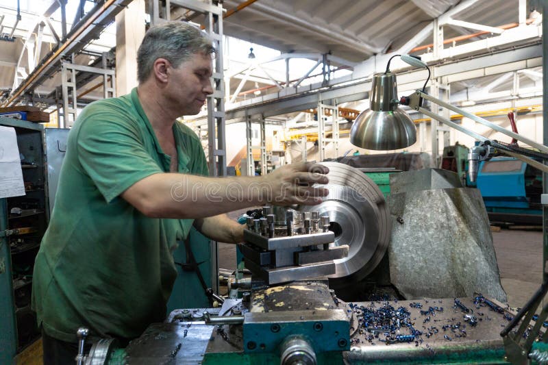Worker, a Man Processes Metal Products on a Machine. Turning Work in ...