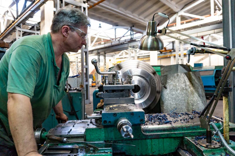 Worker, a Man Processes Metal Products on a Machine. Turning Work in ...