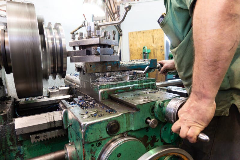 Worker, a Man Processes Metal Products on a Machine. Turning Work in ...