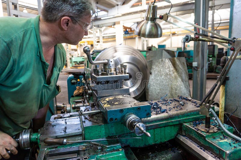 Worker, a Man Processes Metal Products on a Machine. Turning Work in ...