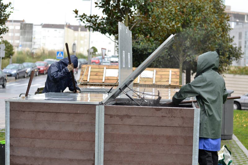 A Worker is Managing a Community Composter Under the Rain. Concept of ...