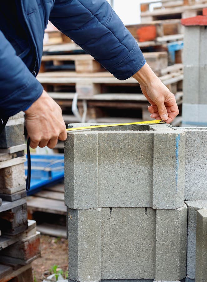 Worker Measures Cement Building Blocks on the Warehouse Stock Photo ...