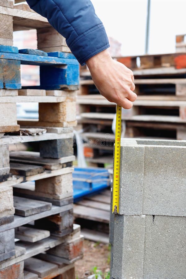 Worker Measures Cement Building Blocks on the Warehouse Stock Image ...
