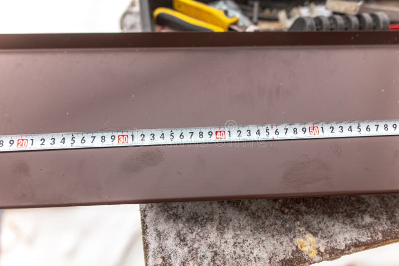 A Worker Measures Metal at a Construction Site with a Meter Stock Image ...