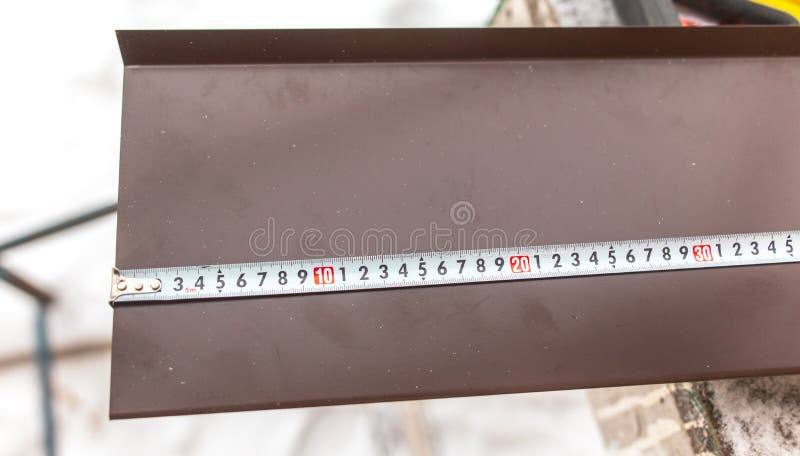 A Worker Measures Metal at a Construction Site with a Meter Stock Photo ...