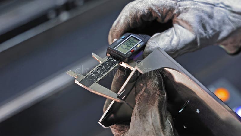 Worker Measuring Metal Part with Digital Caliper. a Gloved Hand is ...