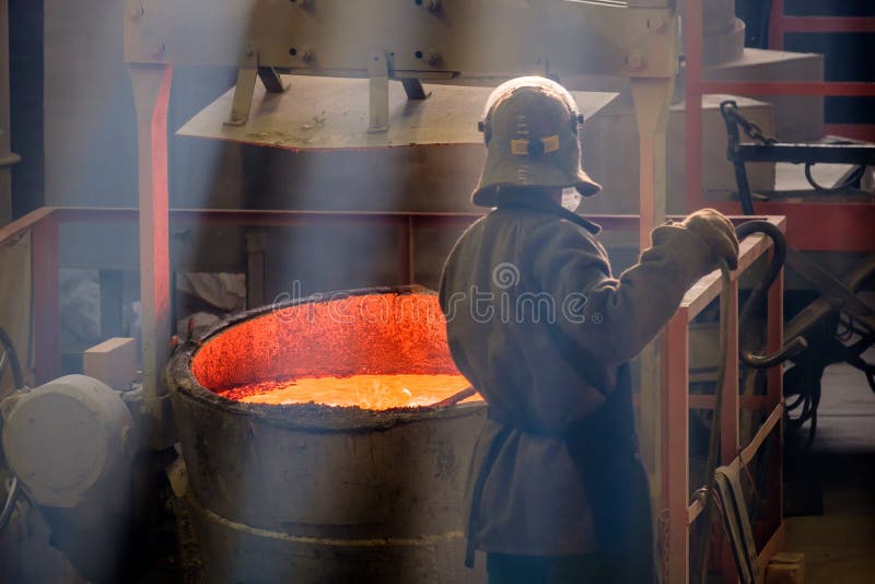 Foundry Worker in a Protective Mask Looks Inside the Vat in Which the ...