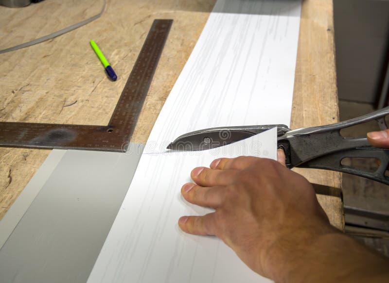 A Worker with Metal Shears Cuts a Strip of the Desired Size Stock Photo ...