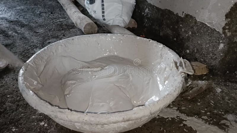 The Worker is Mixing the White Cement Neeru in the Pot with the Help of ...