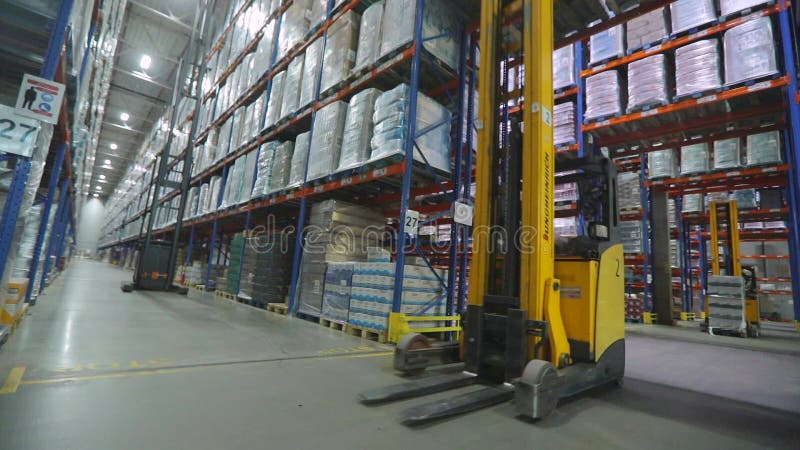 Worker on a Modern Forklift. Working in a Large Modern Warehouse Stock ...