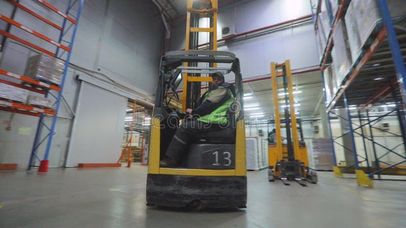 Worker on a Modern Forklift. Working in a Large Modern Warehouse Stock ...
