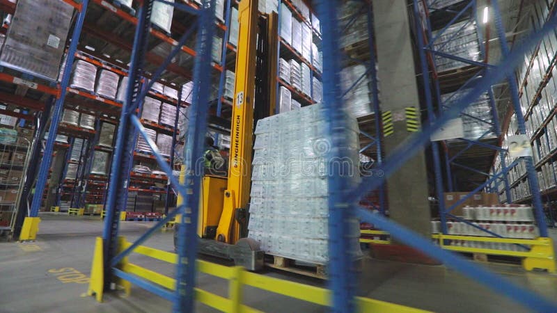 Worker on a Modern Forklift. Working in a Large Modern Warehouse Stock ...