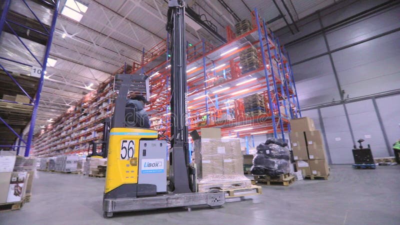 Worker on a Modern Forklift. Working in a Large Modern Warehouse Stock ...
