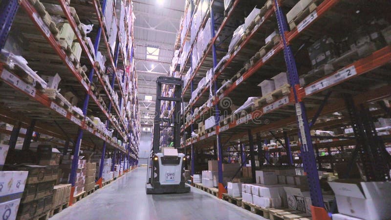 Worker on a Modern Forklift. Working in a Large Modern Warehouse Stock ...