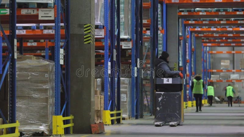 Worker on a Modern Forklift. Working in a Large Modern Warehouse Stock ...