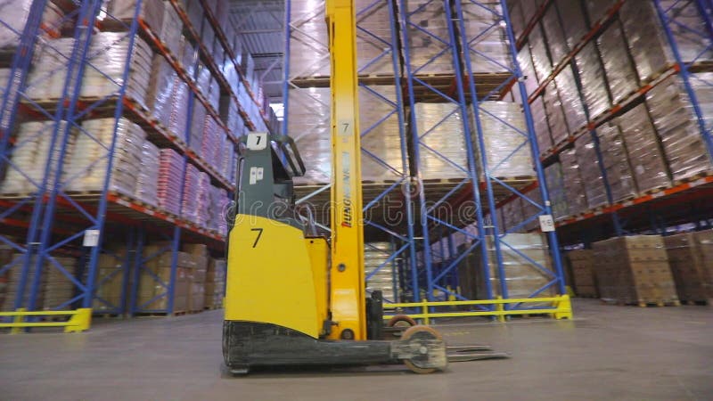 Worker on a Modern Forklift. Working in a Large Modern Warehouse Stock ...