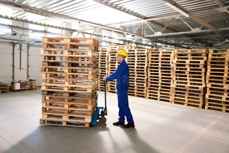 Worker Moving Wooden Pallets with Manual Forklift in Warehouse Stock ...
