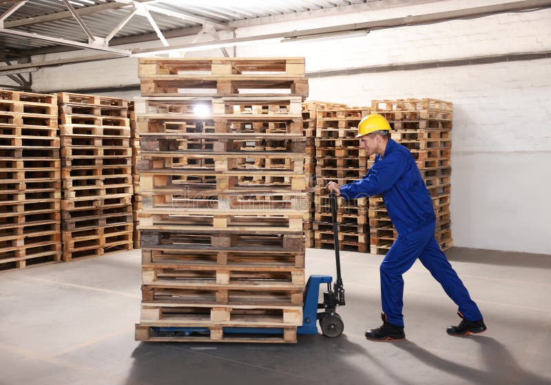 Worker Moving Wooden Pallets with Manual Forklift in Warehouse Stock ...
